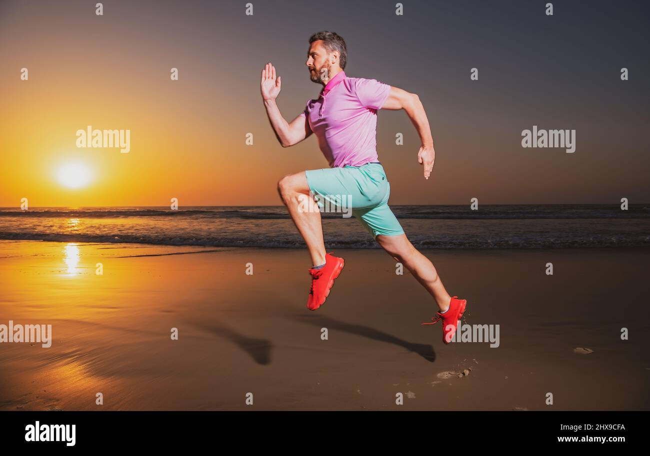 Sporty man runner running in summer sea beach. Attractive fit man run ...