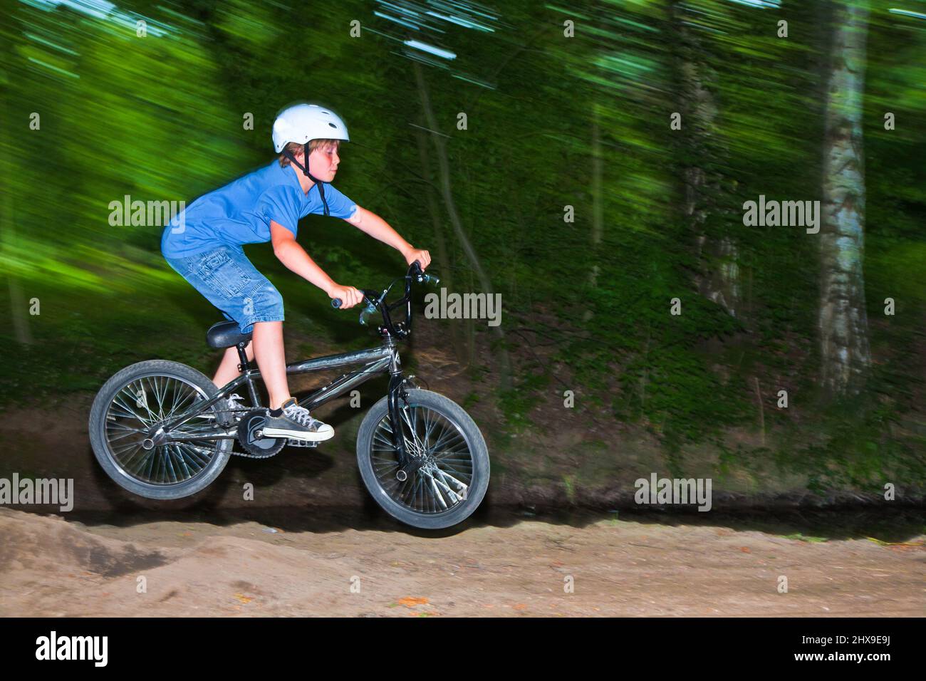 child has fun jumping with thé bike over a ramp in open area Stock ...