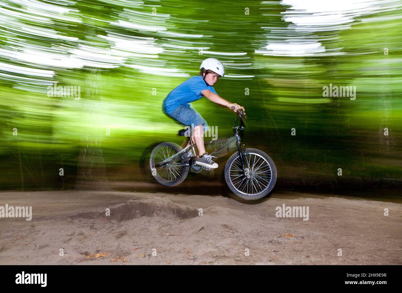 child has fun jumping with the bike over a ramp in open area Stock ...