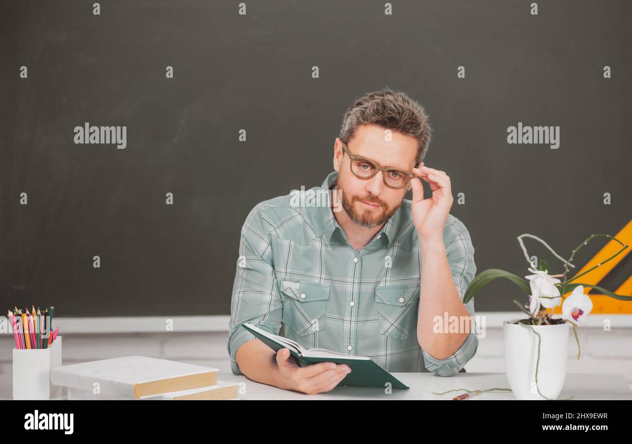 Portrait of male teacher teaching line of high school students with ...