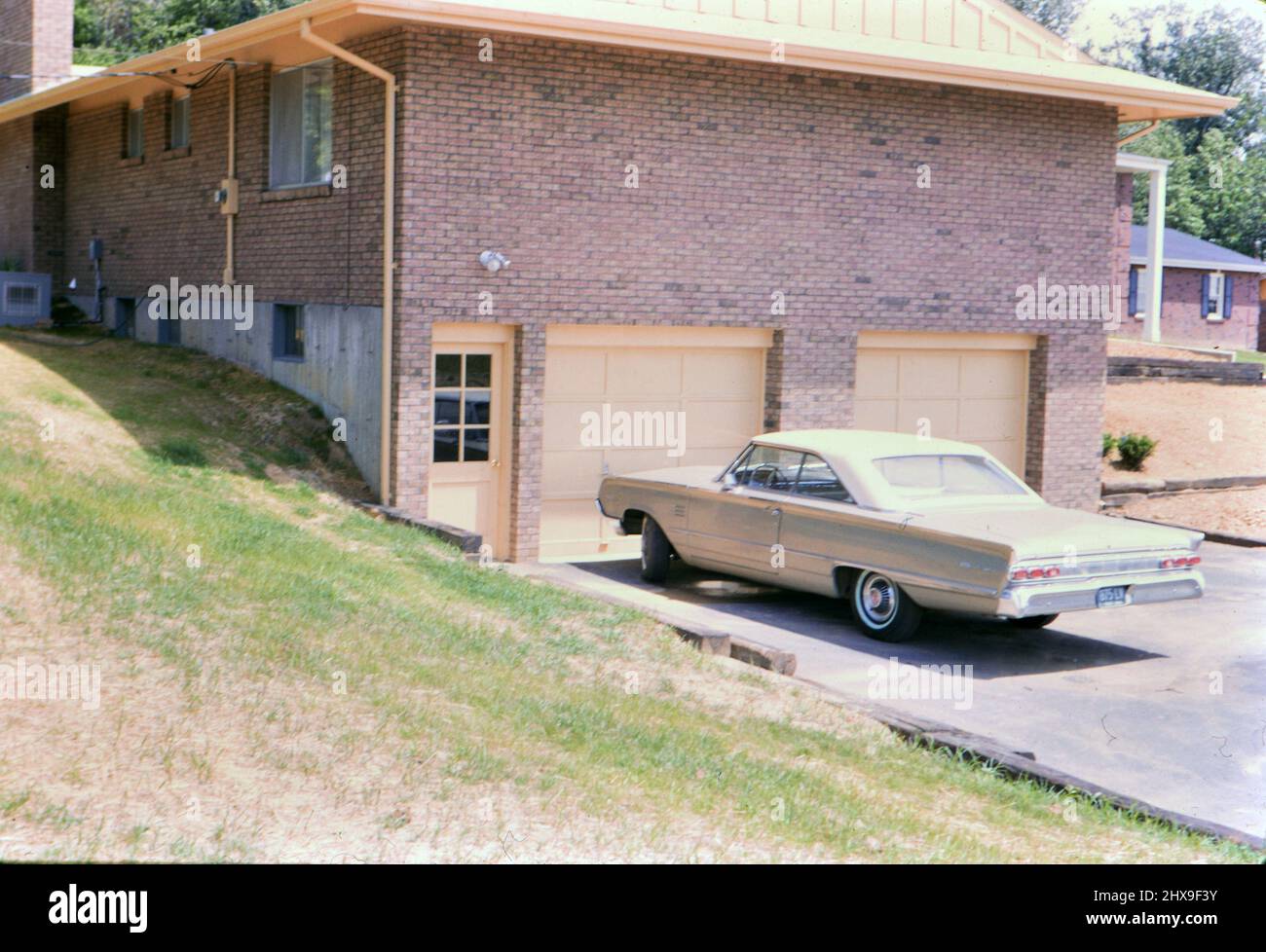 Car parked in the driveway outside a brick home ca. 1964 Stock Photo ...