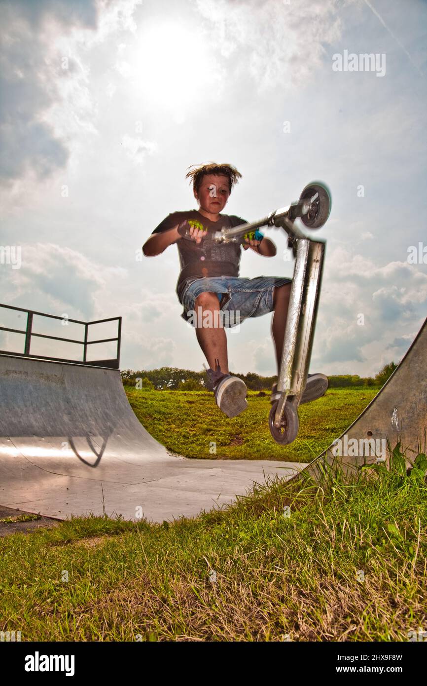 happy boy is jumping with scooter in pipe Stock Photo - Alamy