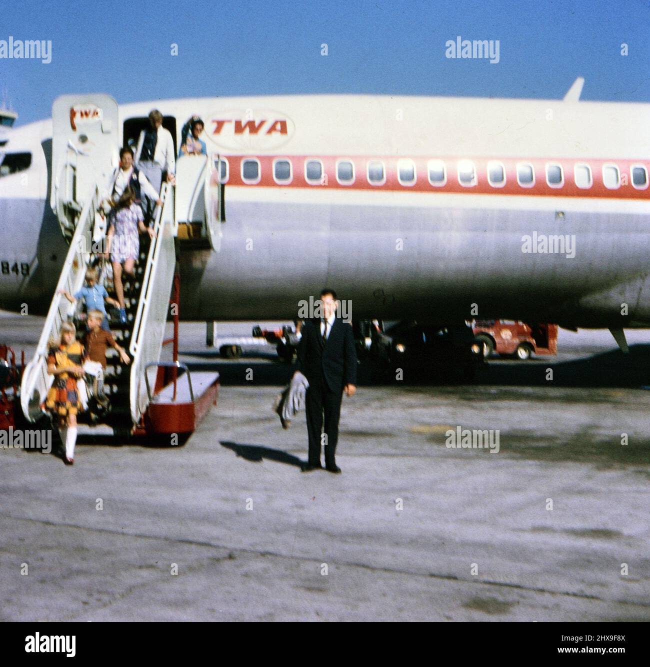 Passengers exiting a TWA airplane on an airport tarmac ca. 1971 Stock ...