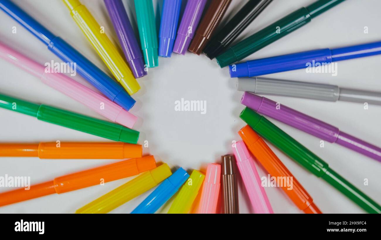 Many colored pencils are arranged around the edges of the image as a ...