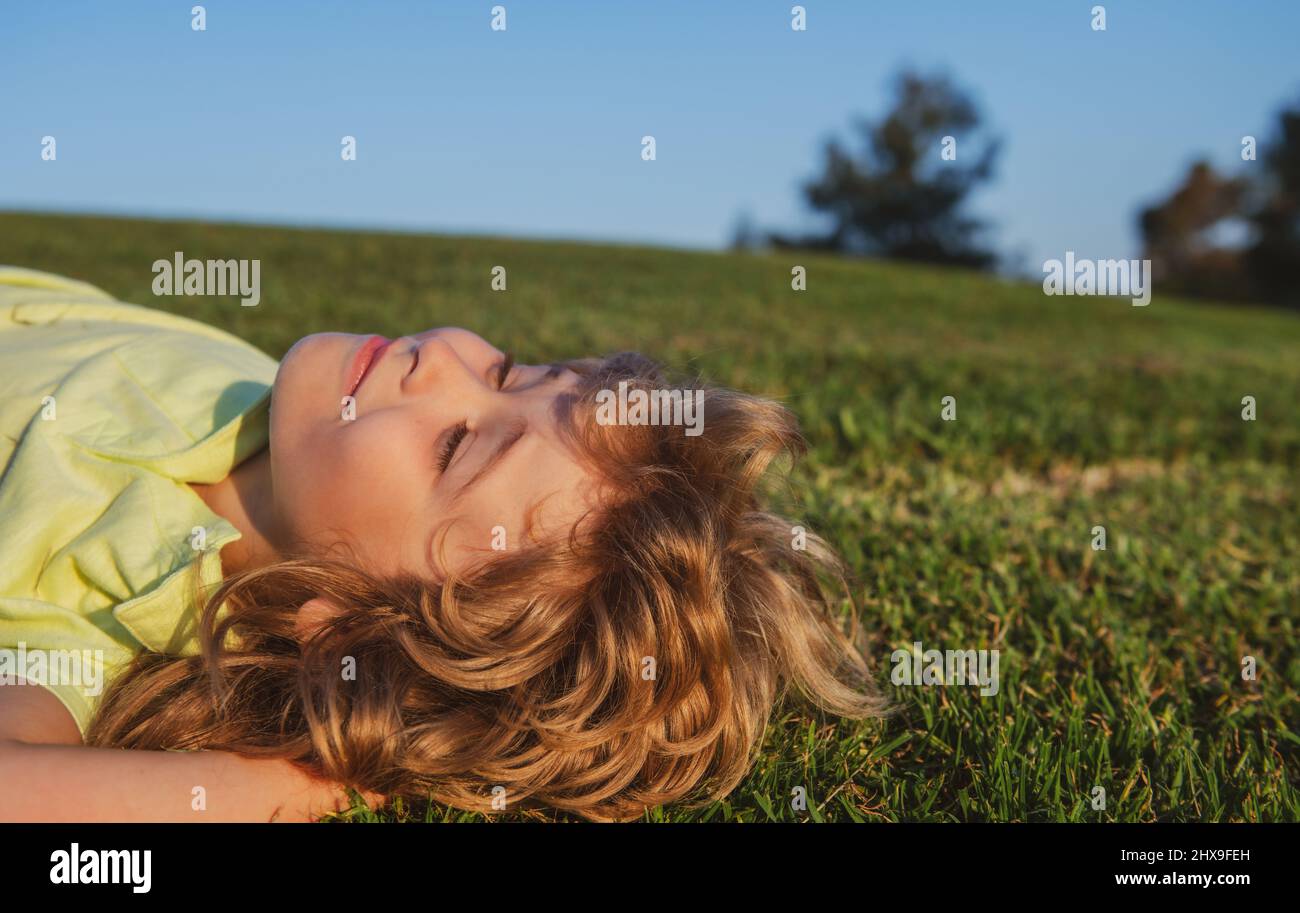 Happy child playing on green grass. Kids dreaming. Funny kid outdoor in ...