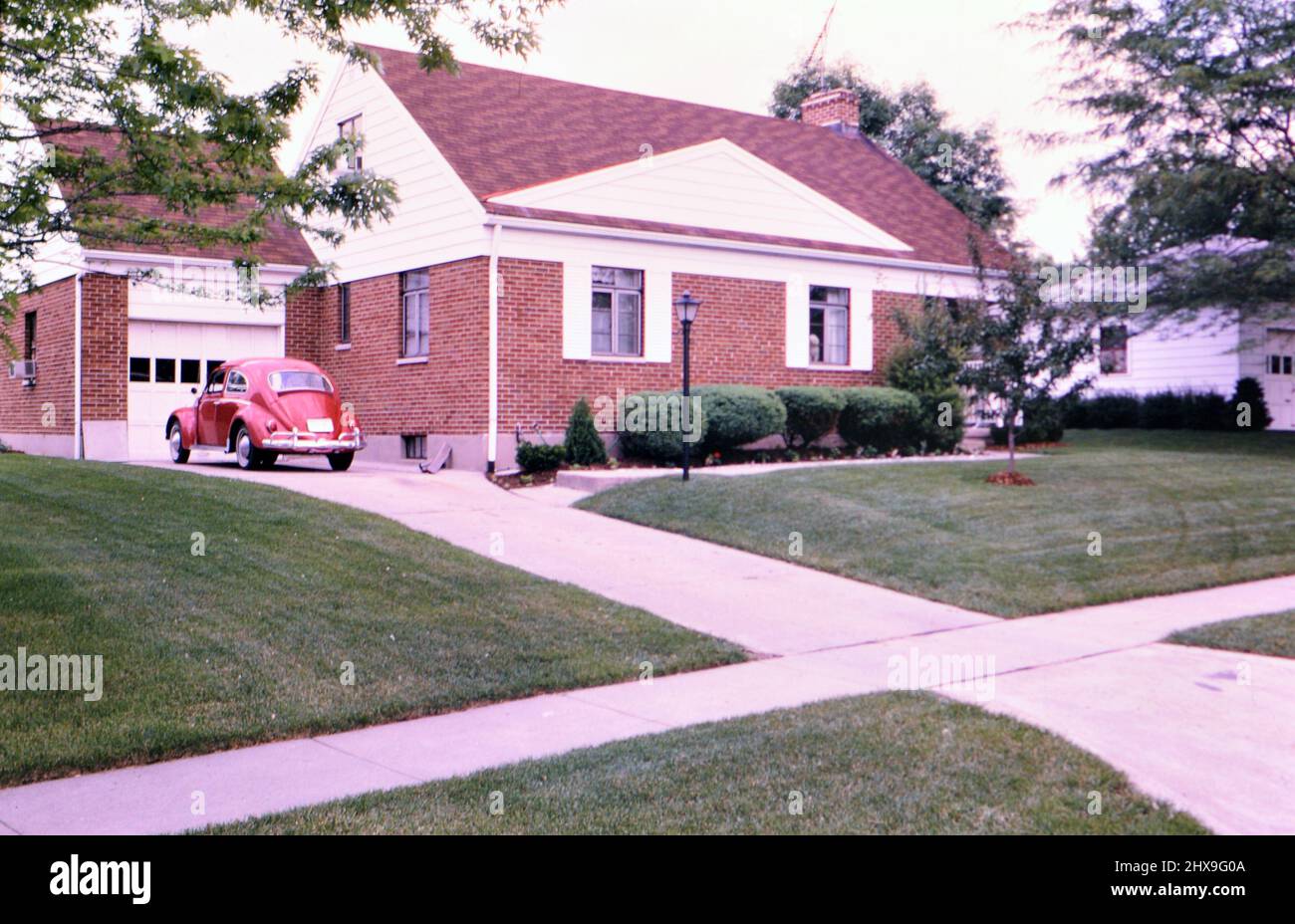 Volkswagen Beetle car parked in a driveway of a red brick house ca ...