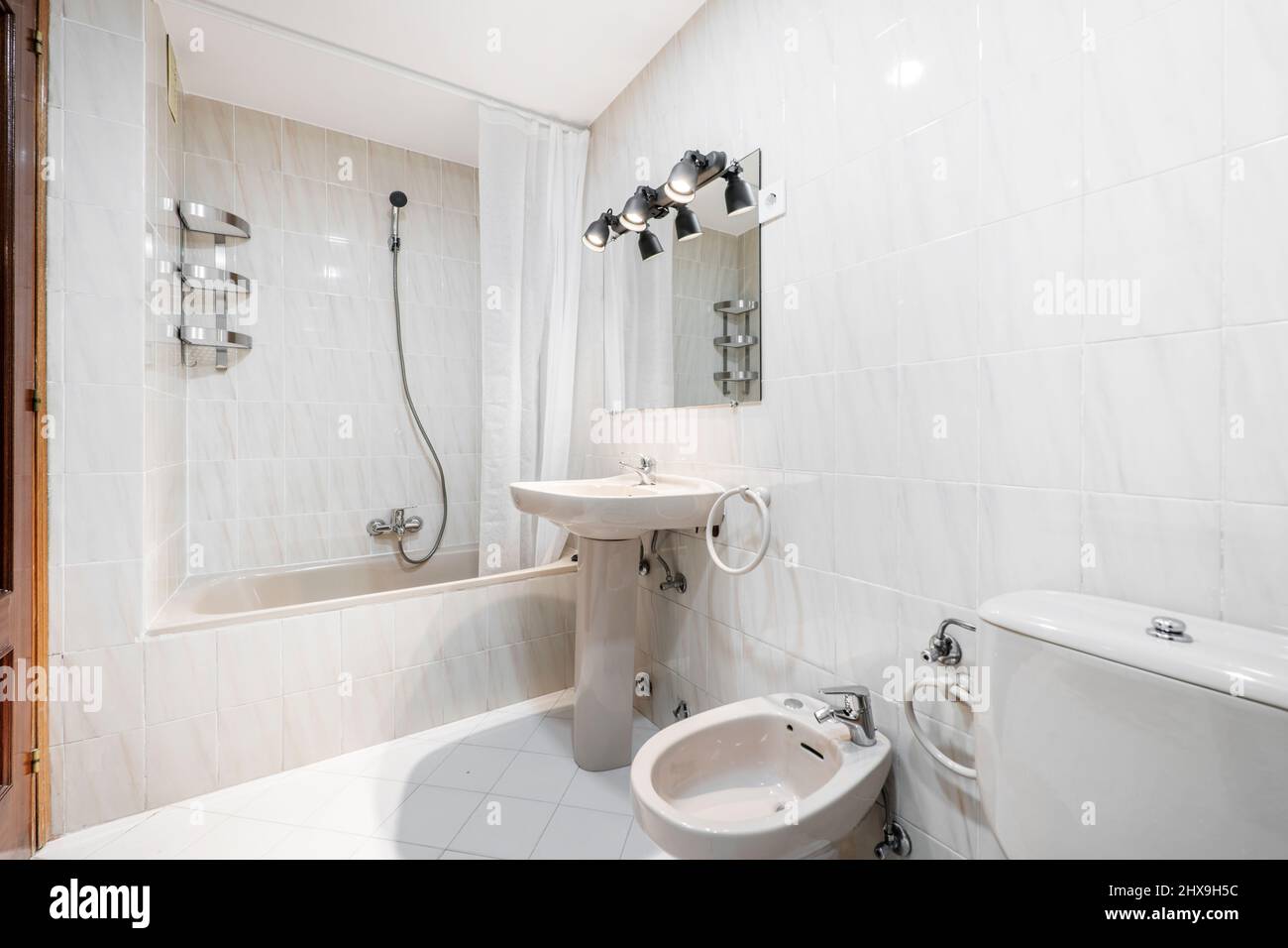 Bathroom with stainless steel fixtures, fabric curtained tub and cream ...
