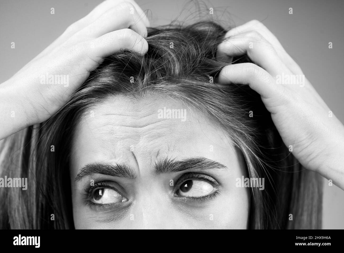 Sad woman looking at damaged hair, the hair loss problem. Studio ...