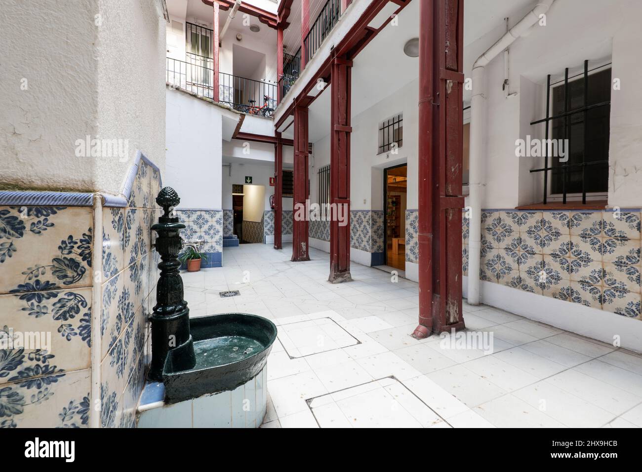Patio of a typical Madrid corrala with tiles with floral motifs, wooden ...