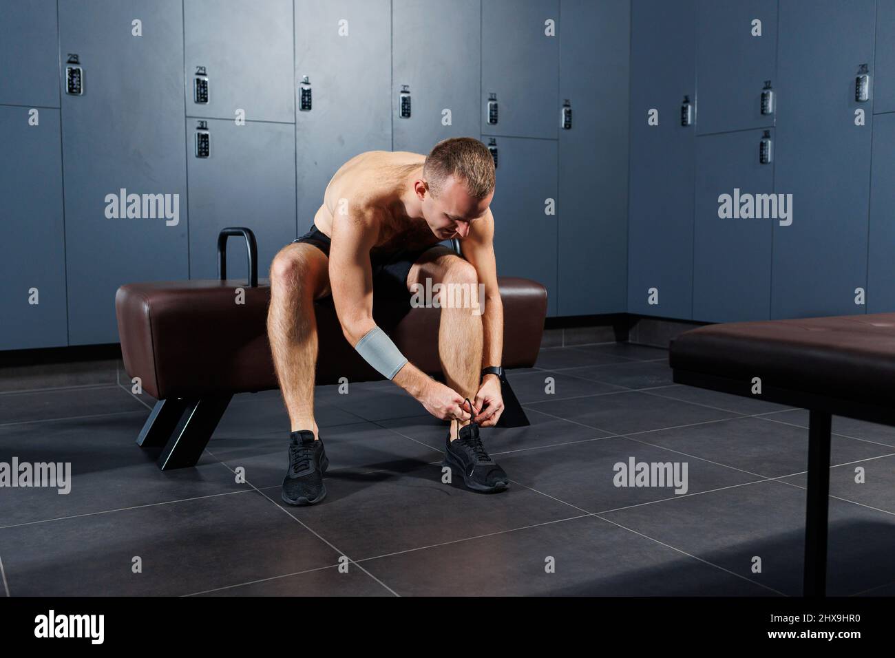 A young man changes clothes in a room in the gym before training Stock ...