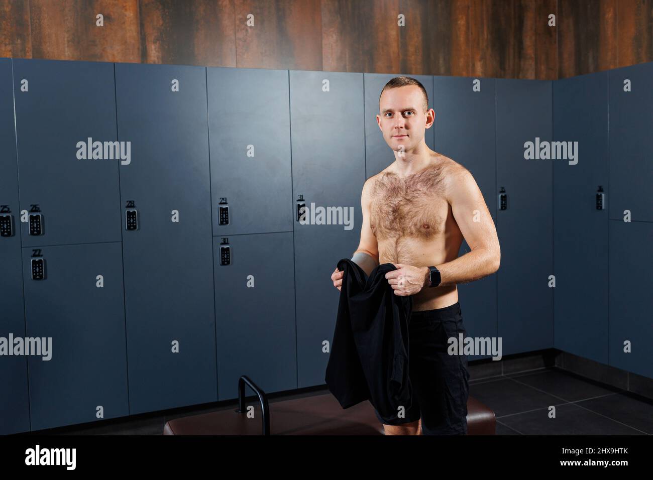 A young man changes clothes in a room in the gym before training Stock ...