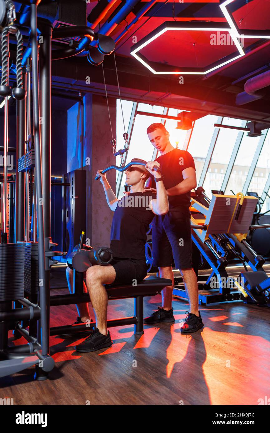 A strong male doing heavy back exercises in the gym under the ...