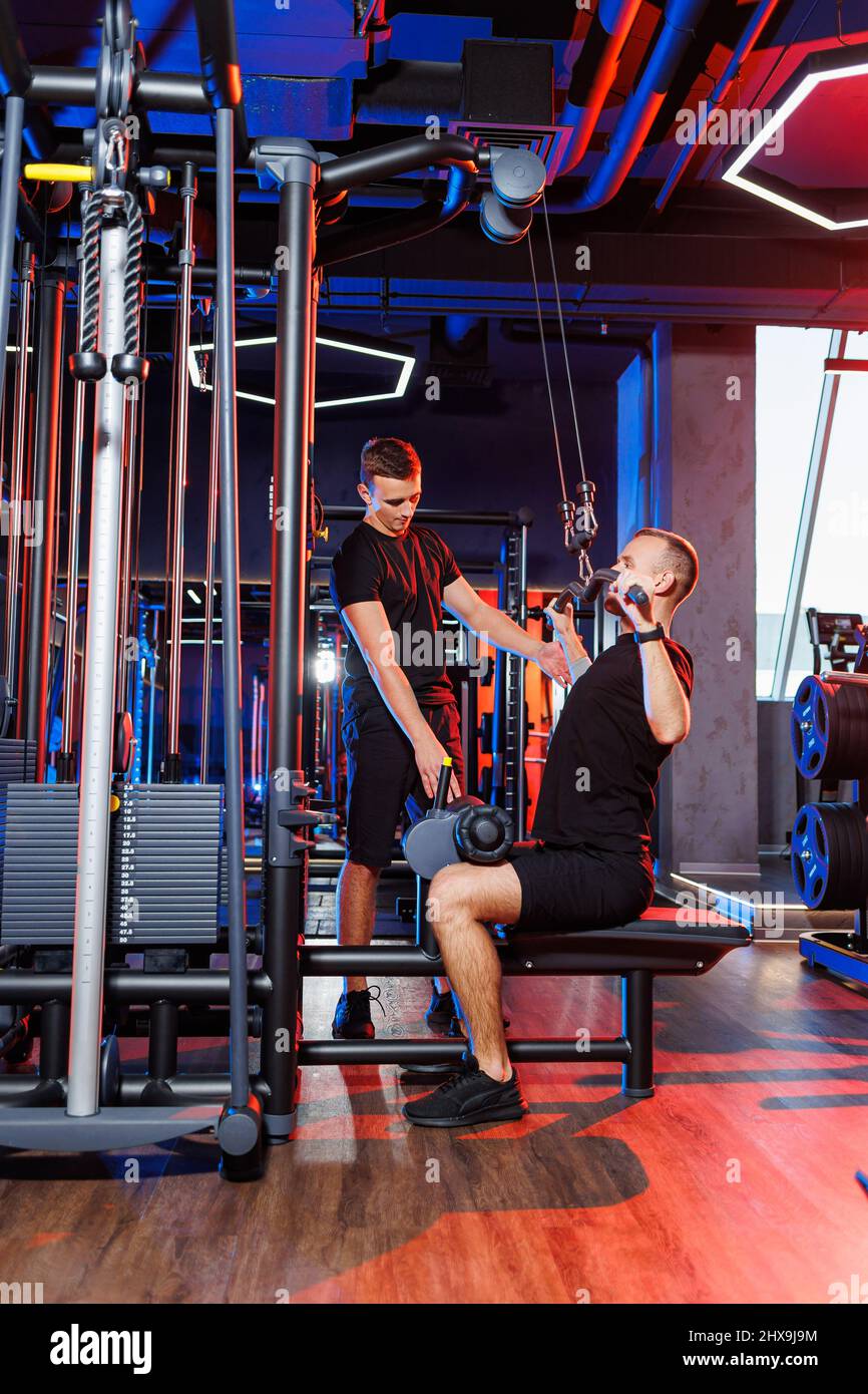 A strong male doing heavy back exercises in the gym under the ...