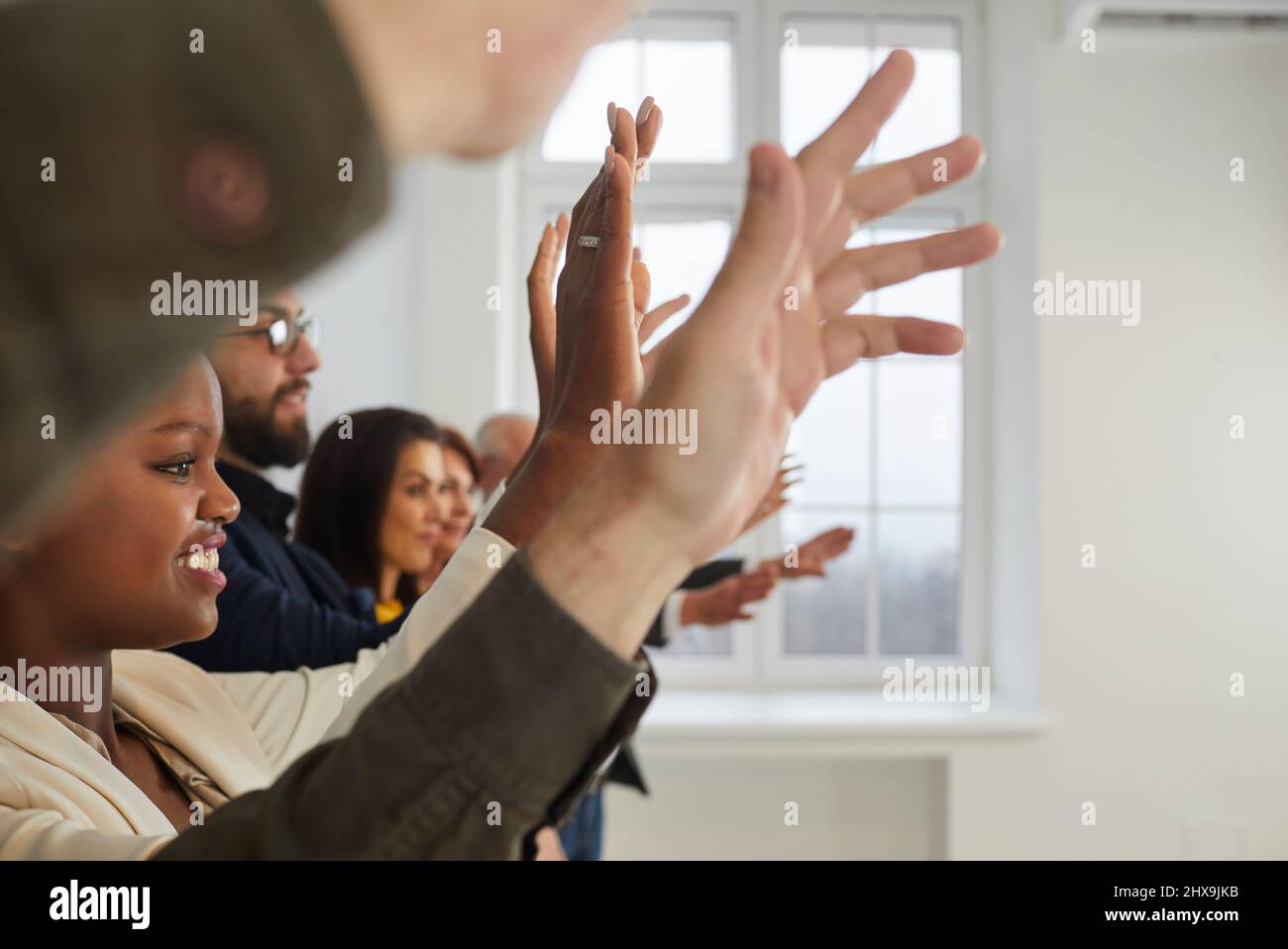 Happy diverse audience raising hands to ask questions during ...