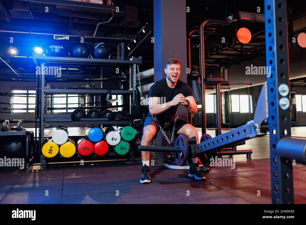 Handsome muscular man performing heavy exercises in the gym. Healthy ...