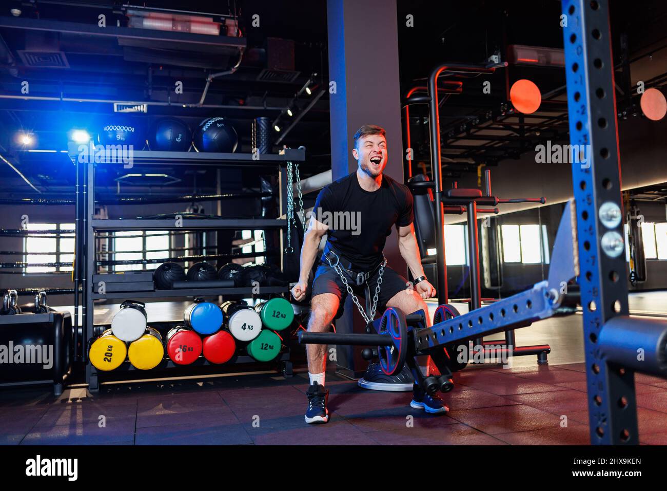 Handsome muscular man performing heavy exercises in the gym. Healthy ...