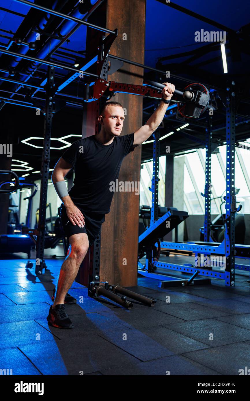 Handsome muscular man performing heavy exercises in the gym. Healthy ...