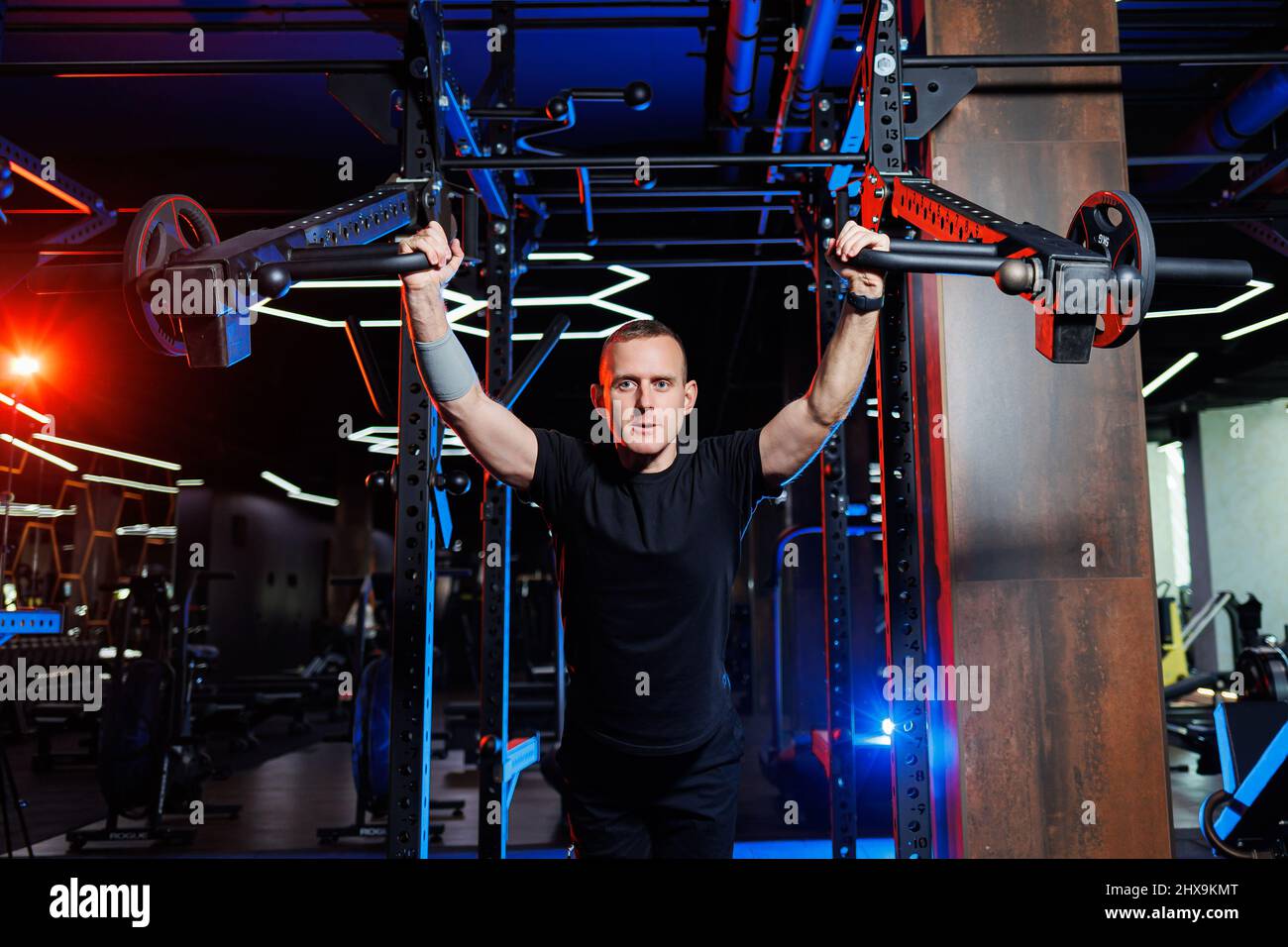 Handsome muscular man performing heavy exercises in the gym. Healthy ...