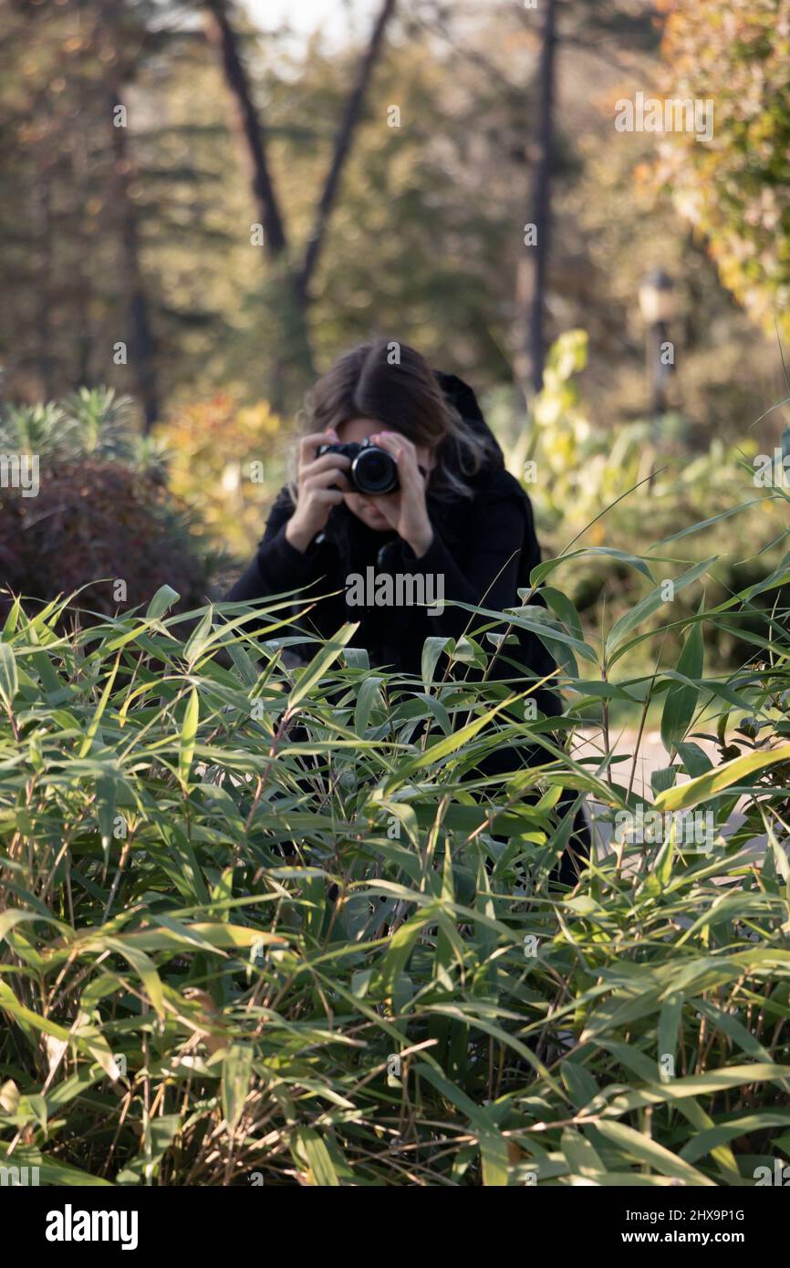 Camouflage wildlife photographer. A woman is hiding while taking photos ...