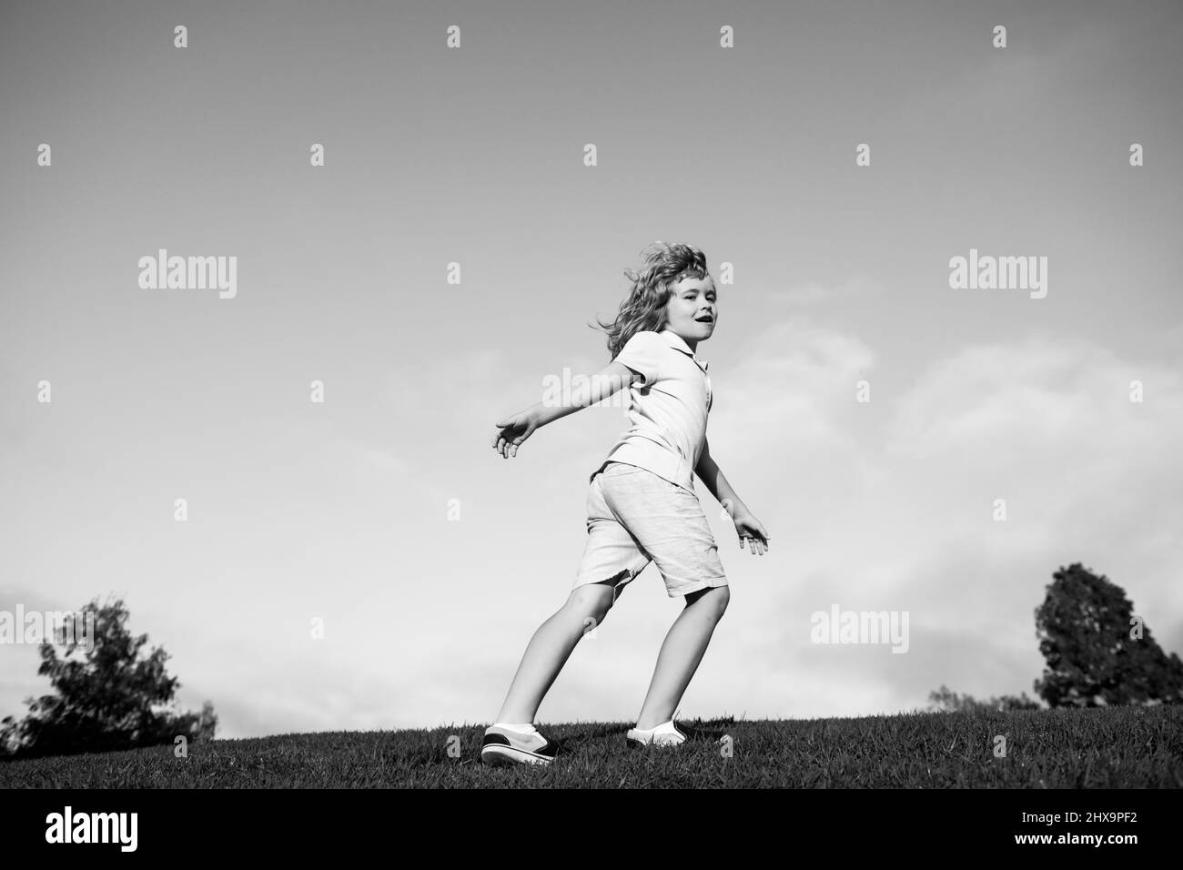 Kid running on grass field. Cute boy run in summer park. Child running ...