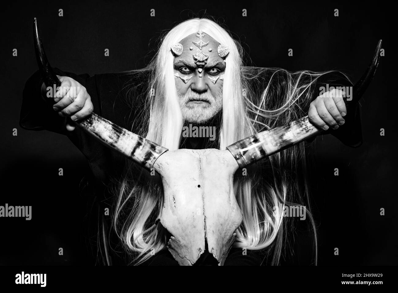 Devil horror concept. Elderly man holding two red horns. Monster with ...