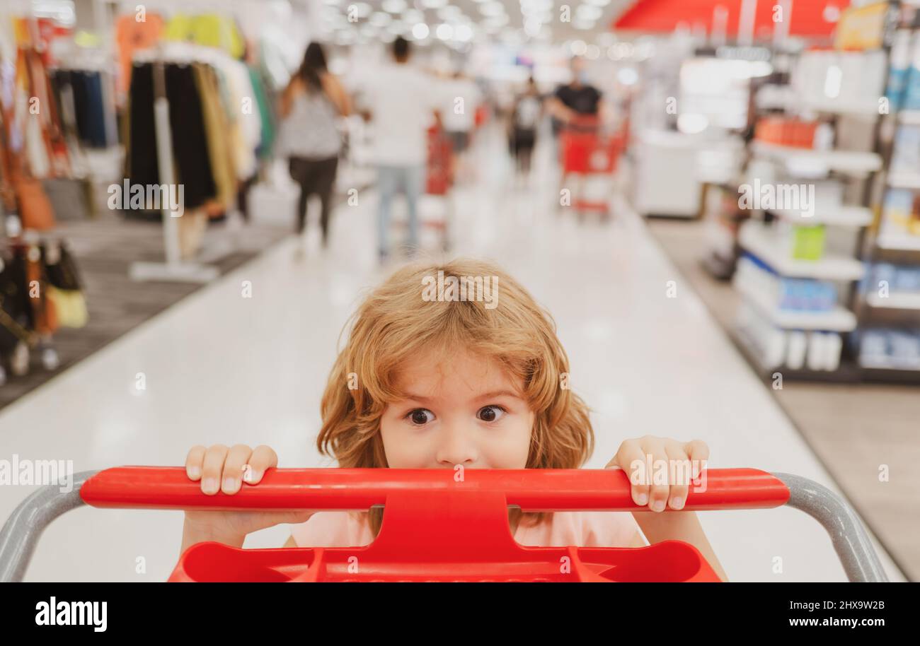Amazed kid boy with shopping cart at grocery store or supermarket Stock ...