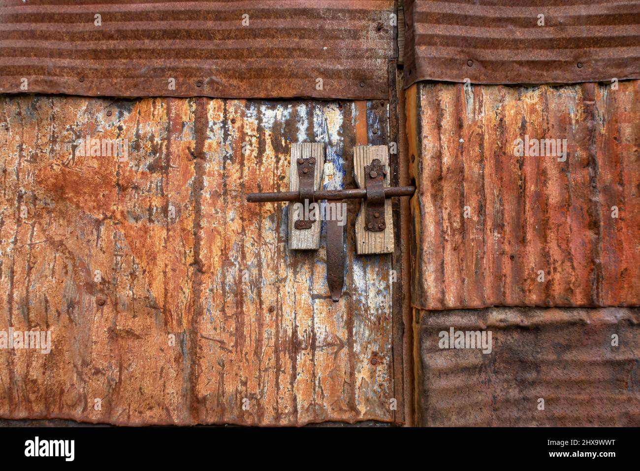 door made of rusted sheet steel plates, with a closed latch in its ...
