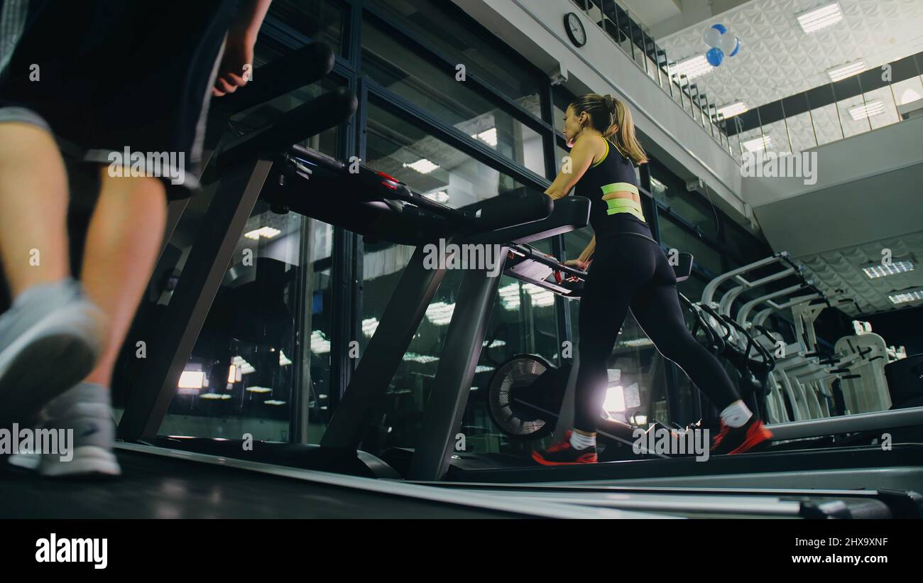 Fit Athletic Woman Running on the Treadmill, Doing Her Fitness Exercise ...