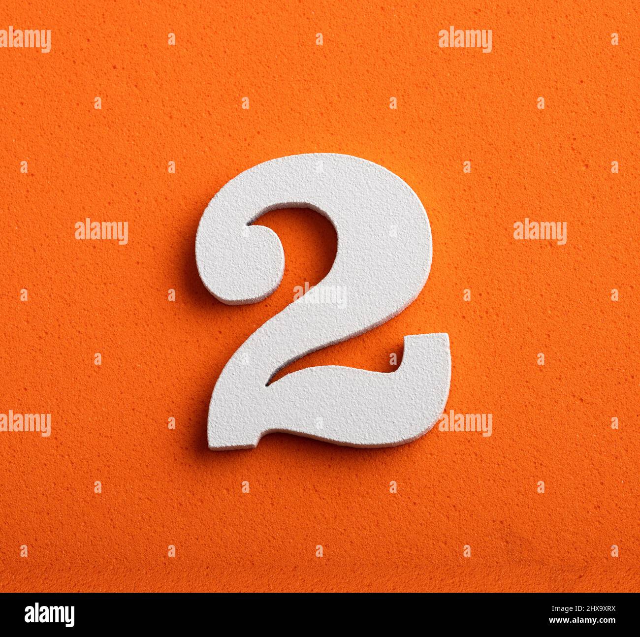 Two, white wooden number on orange background Stock Photo - Alamy