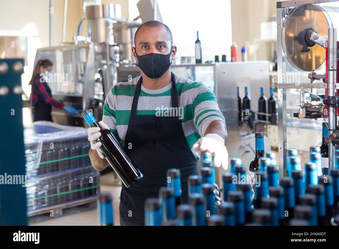 Worker of winery posing with bottled wine Stock Photo - Alamy