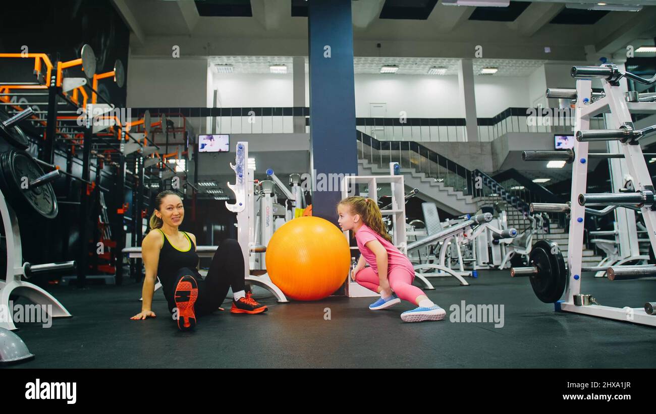 Mother and Daughter in the Gym, Family Performs Physical doing ...