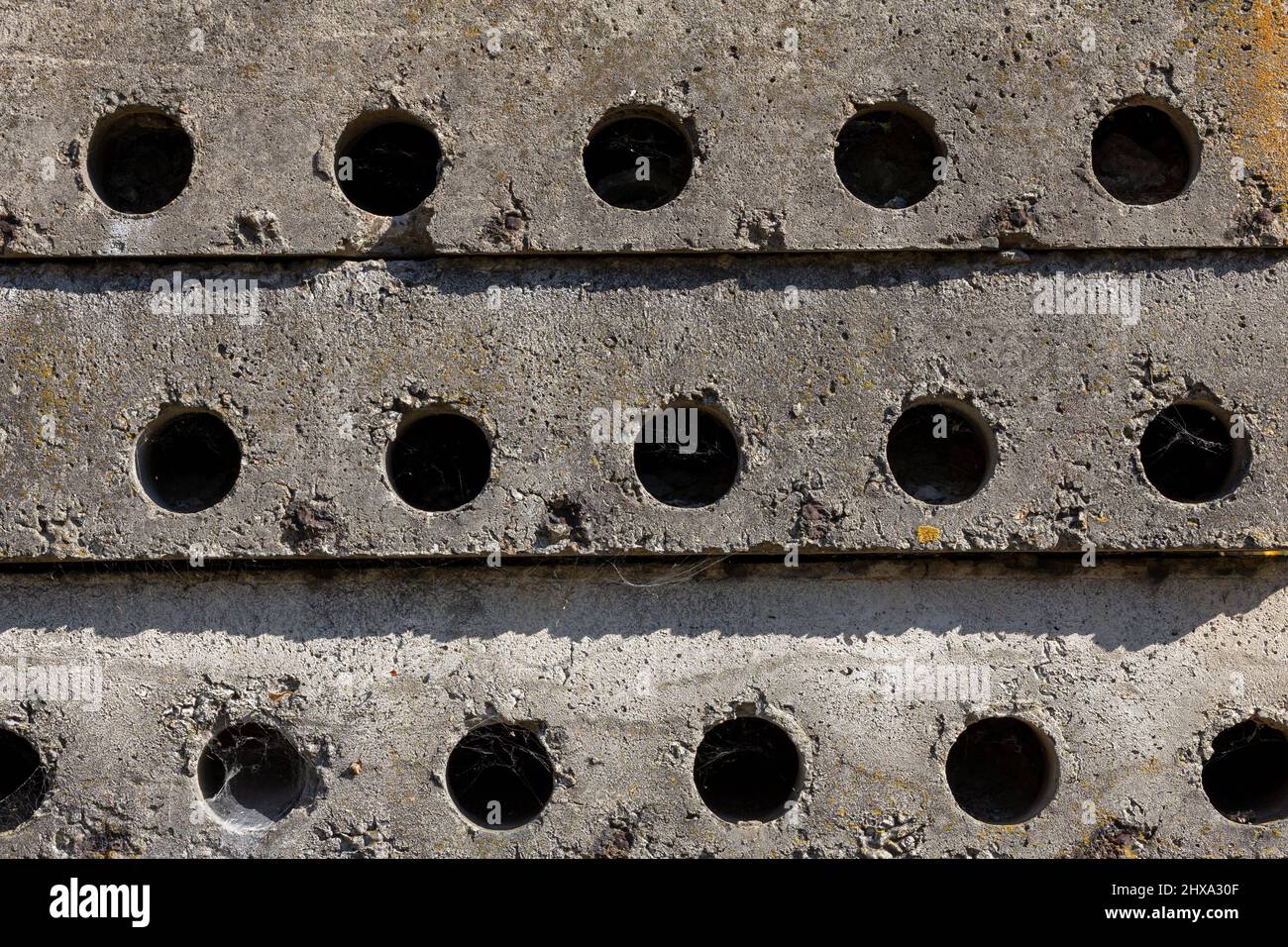 Linear texture of old gray concrete slabs block with holes stacked on ...