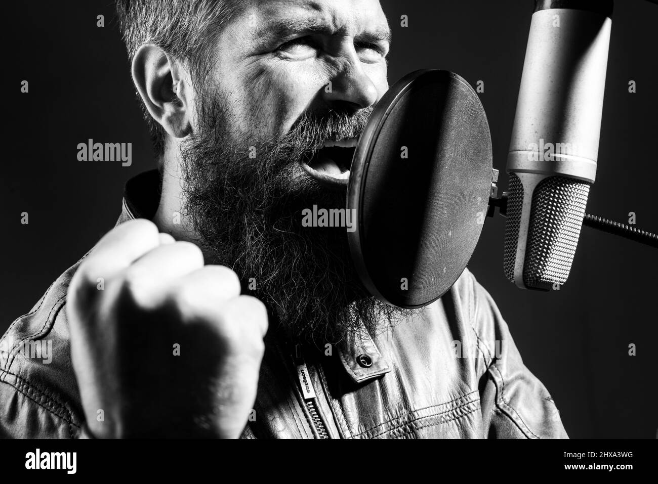 Singer wearing headphones is performing a song with a microphone while ...