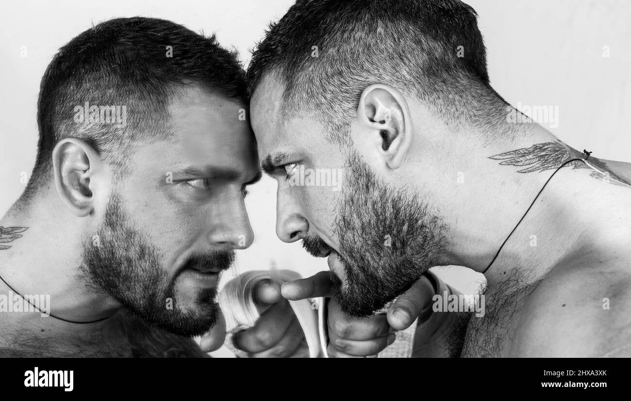 A mirror where a man watching himself. Man and mirror. Bearded hispanic ...