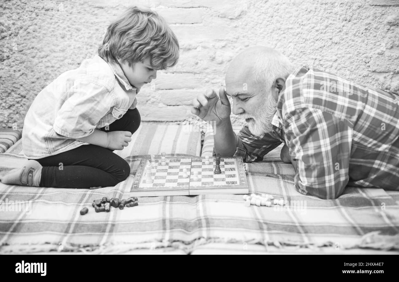 Senior man teaching his grandson to play chess. Handsome grandpa and ...