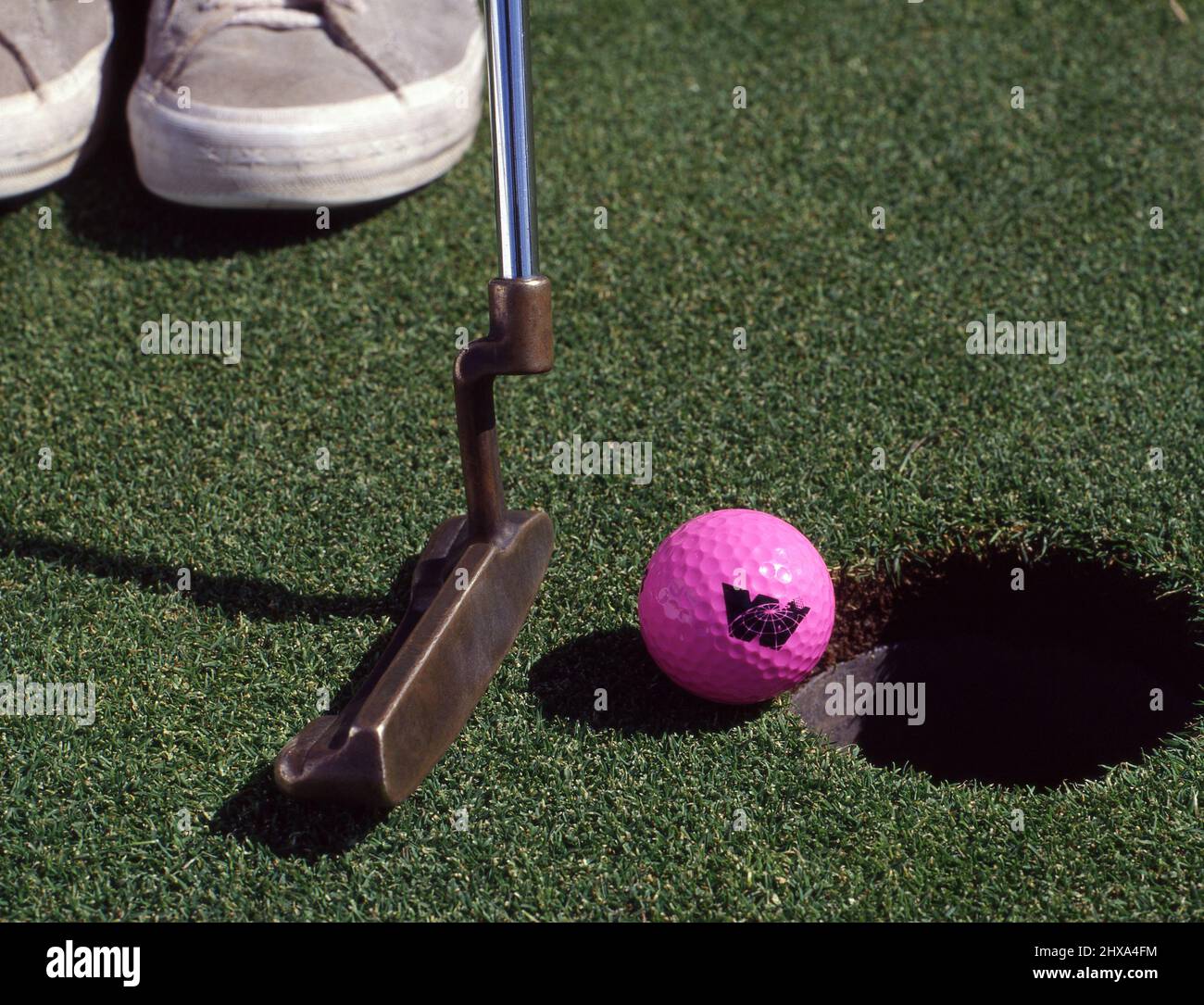 GOLFER USING PUTTER TO DRIVE BALL INTO THE HOLE Stock Photo - Alamy