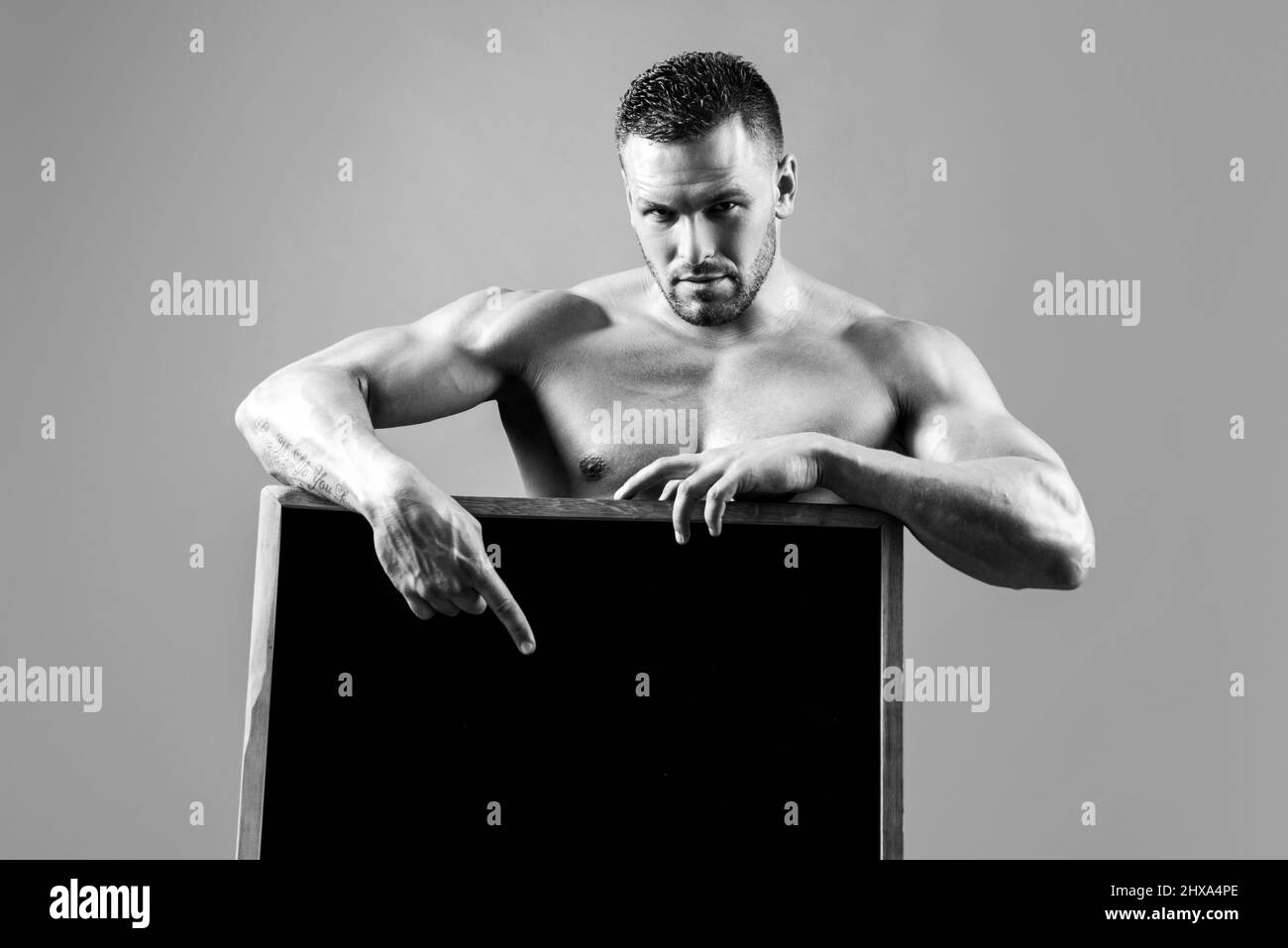 Fitness man with sign ad board. Strong bodybuilder macho holding blank ...