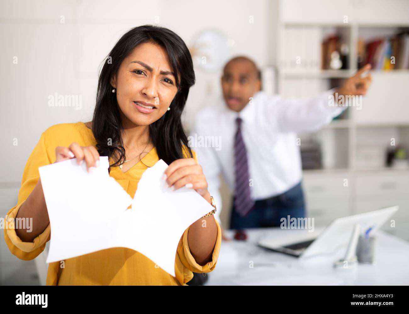 Upset female office employee tearing piece of paper Stock Photo - Alamy