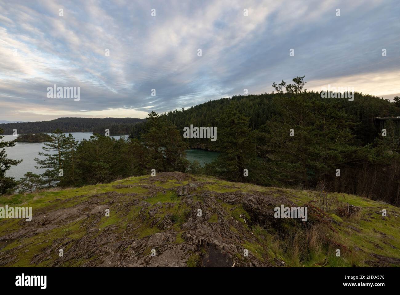 forest hills surrounding inlet with island and clouds Stock Photo - Alamy