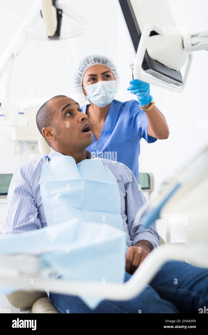 Woman stomatologist explaining treatment to patient in dental office ...