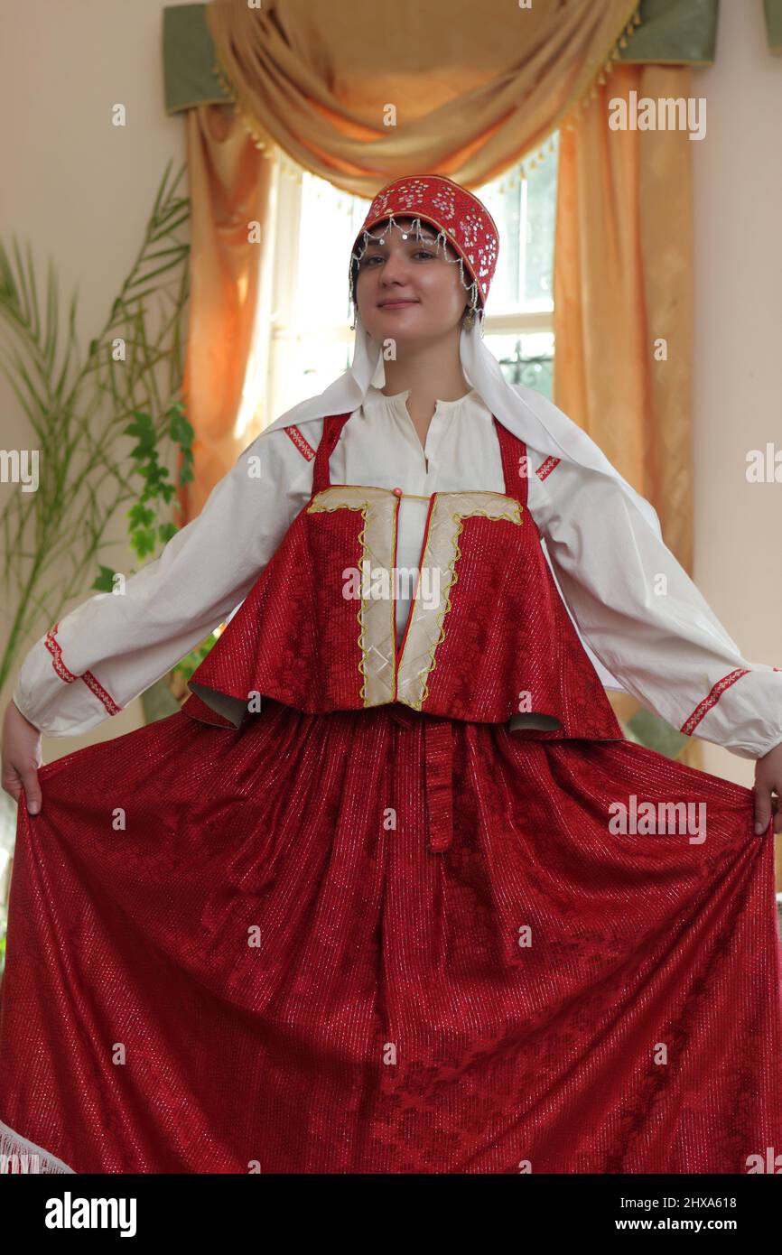 The young woman poses in a red sarafan Stock Photo - Alamy