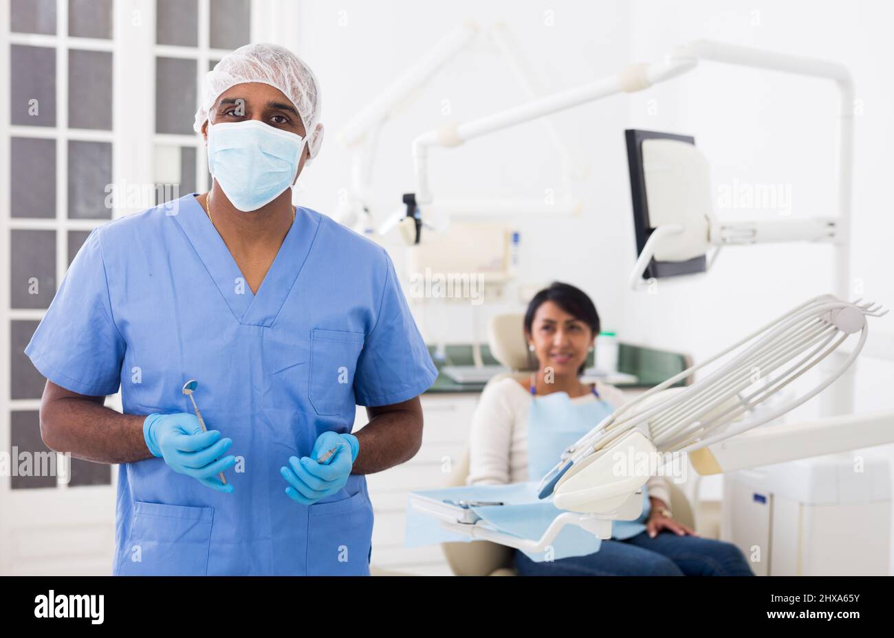 Professional dentist standing with patient background Stock Photo - Alamy