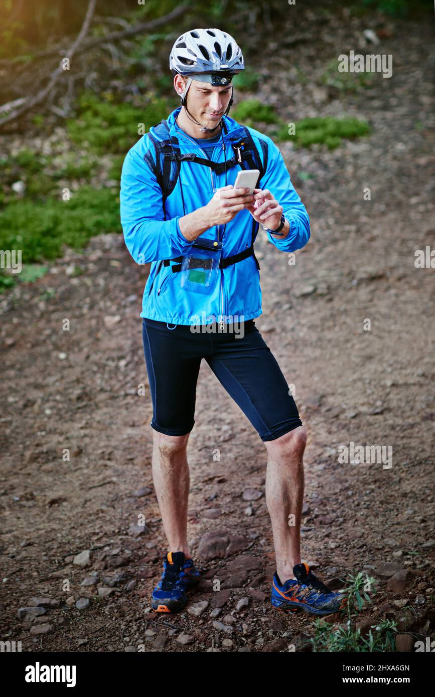 Taking a look at the directions. Shot of a cyclist using his smartphone ...