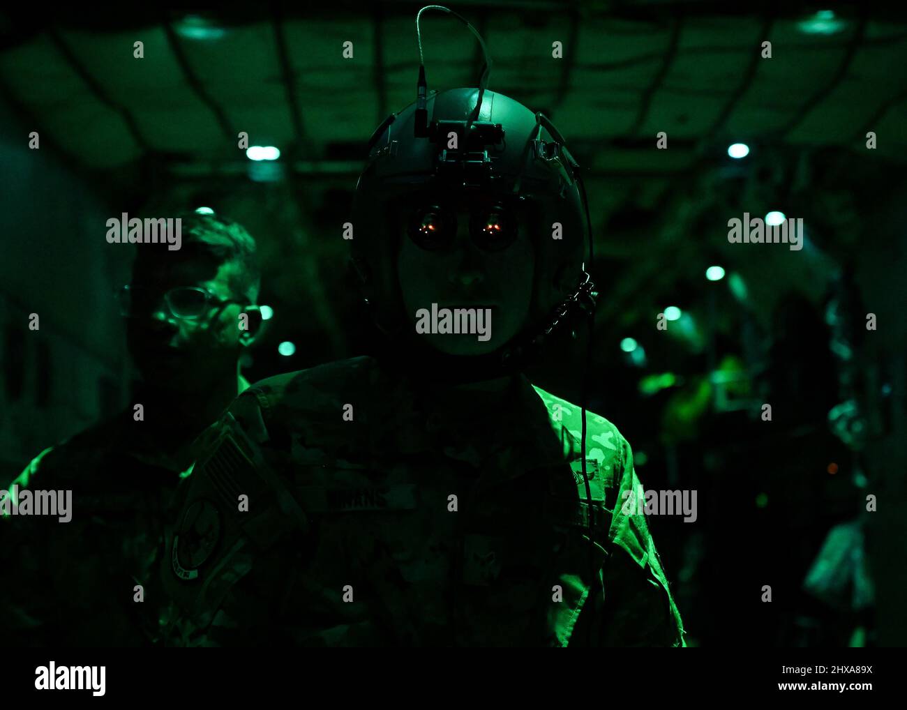 A loadmaster from the 41st Airlift Squadron uses night vision goggles ...