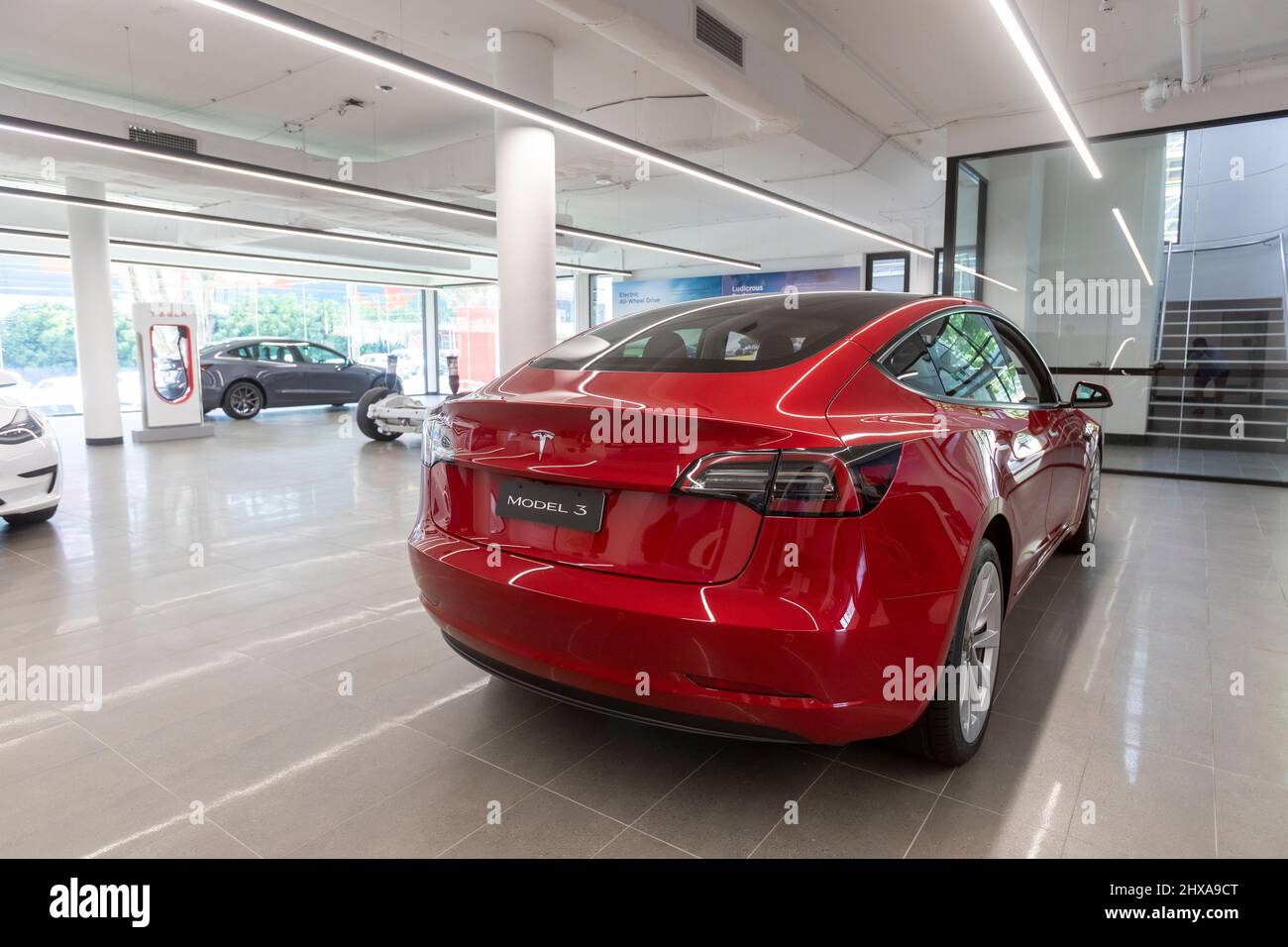 Tesla car showroom interior with 2022 Tesla model 3 car in red on ...