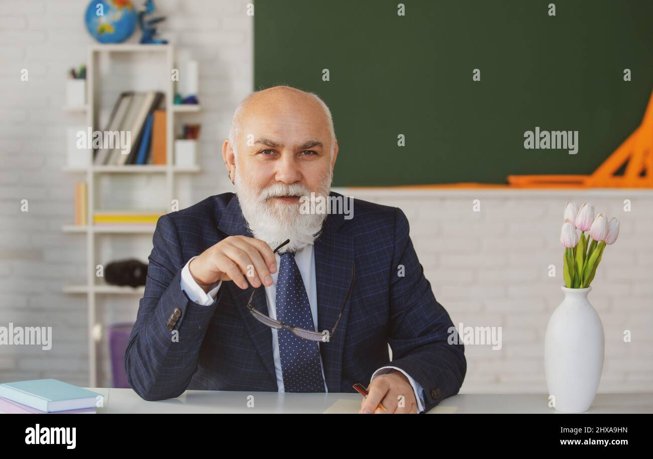 Senior academic professor on lecture near empty blackboard. Knowledge ...