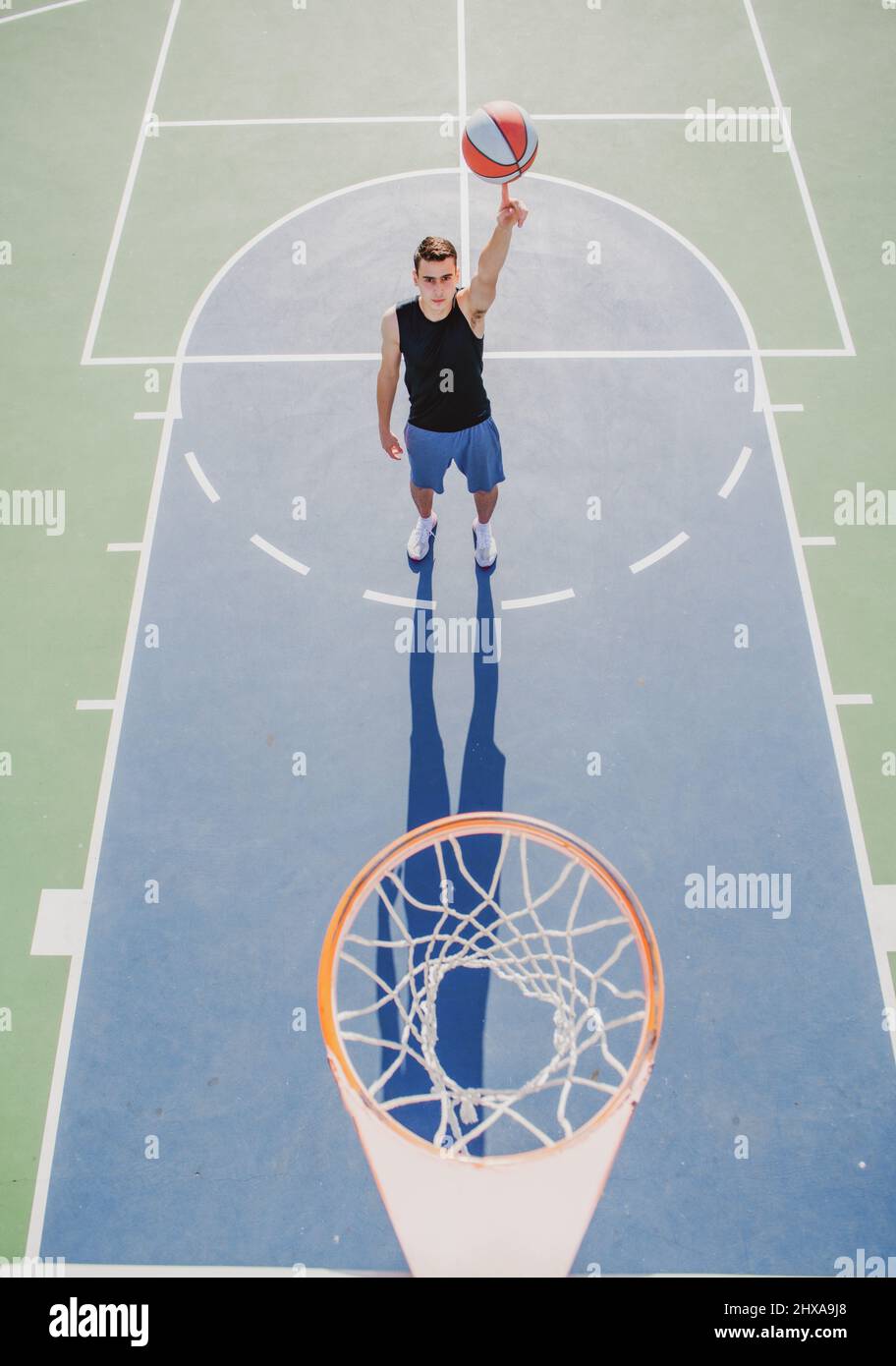Angle view of man playing basketball, above hoop of man shooting ...