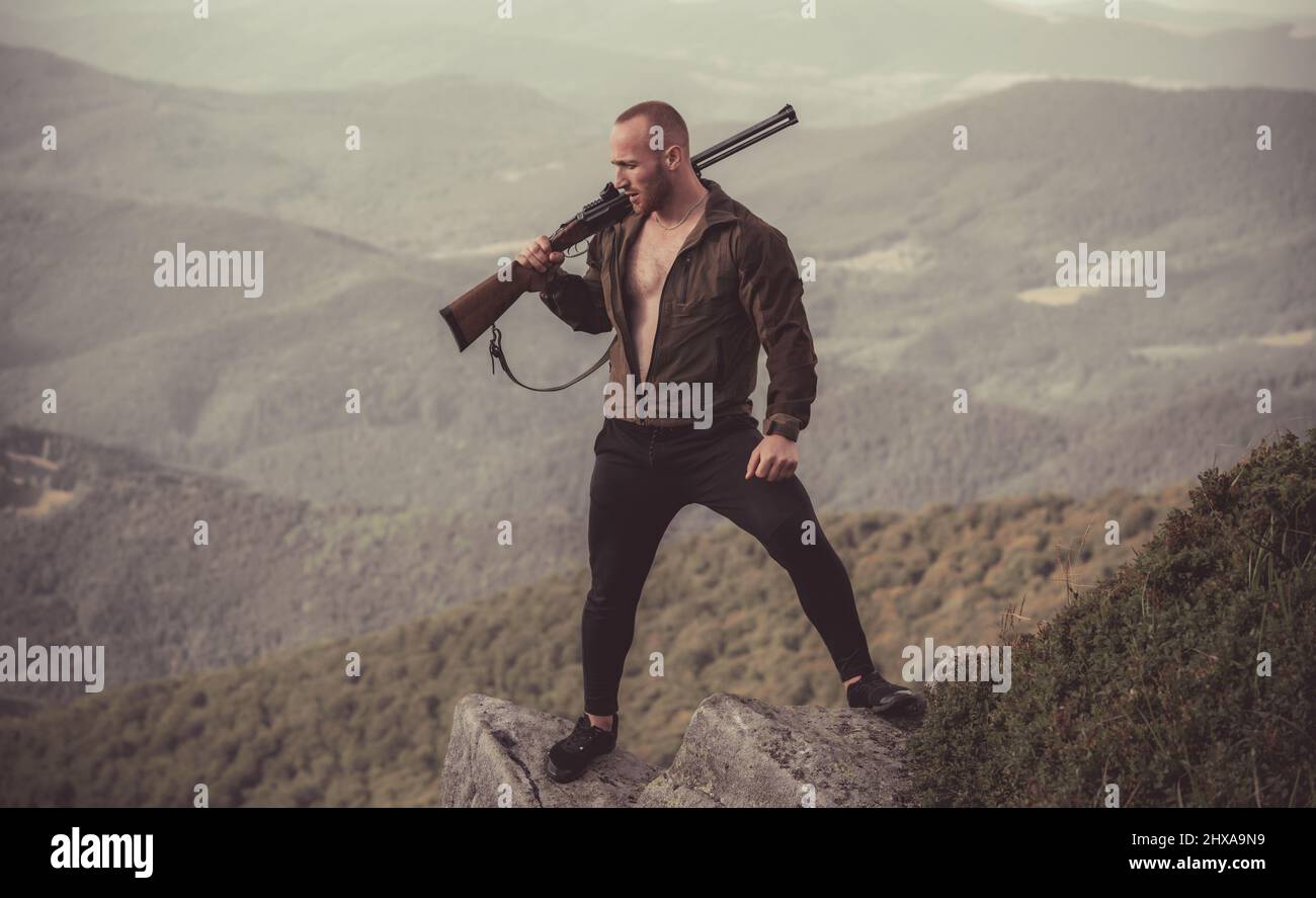 A hunter with a hunting gun hunt in summer forest. Man hunter with a ...