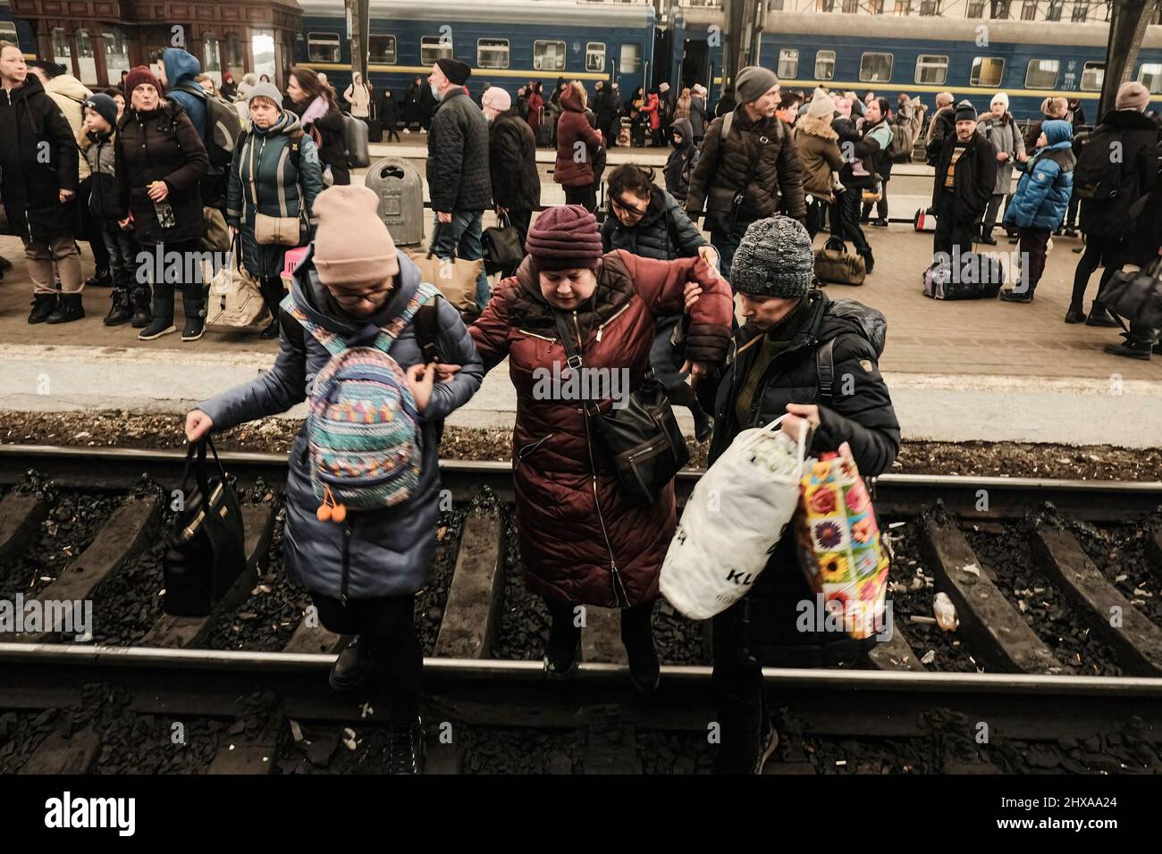 Lviv, Ukraine. 10th Mar, 2022. Ukrainian refugees cross the railway to ...