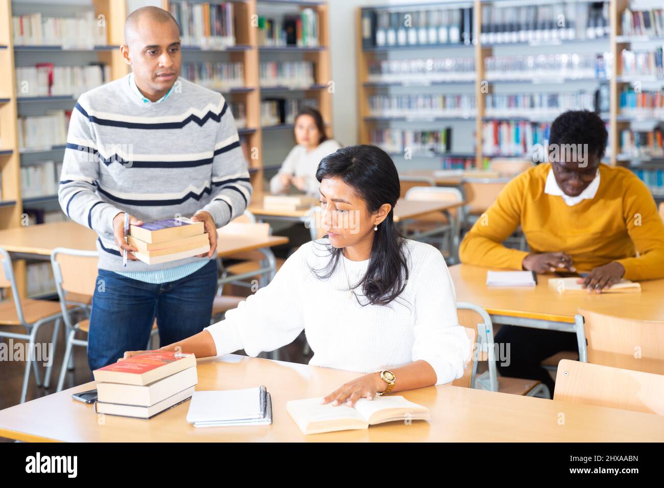 Young adult woman studying in public library Stock Photo - Alamy